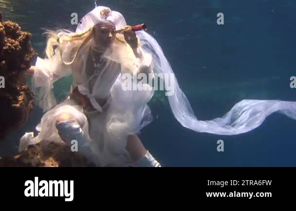 Underwater model free diver in costume pirate swims in clean water in ...