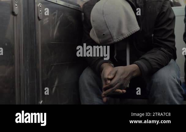 Homeless man in subway train hiding face under the hood Stock Video ...