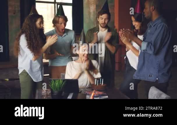Attractive young woman is blowing candles on birthday cake and laughing ...