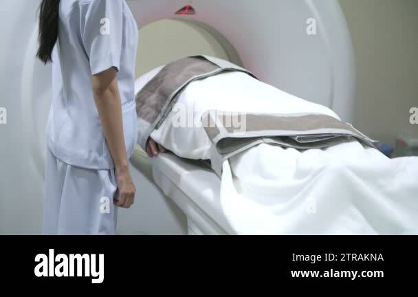 Patient in MRI machine for a CT scan. Senior man cover in blanket going ...