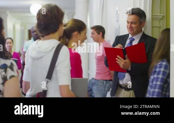 Teacher checking register as students enter classroom Stock Video ...