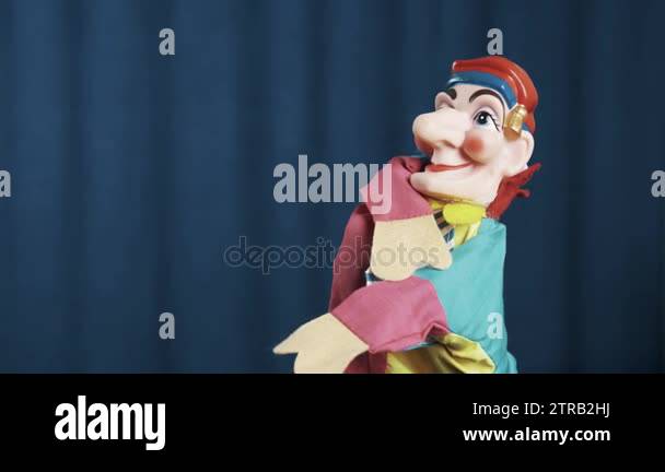 Jester hand puppet dancing and spread arms on scene with blue ...