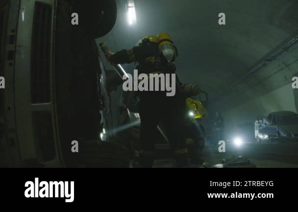 Car accident scene inside a tunnel, firefighters rescuing people from ...