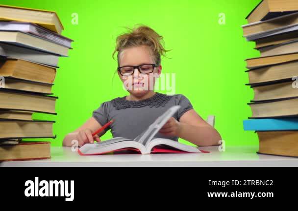 Girl sitting and leafing through the book. Green screen. Slow motion ...