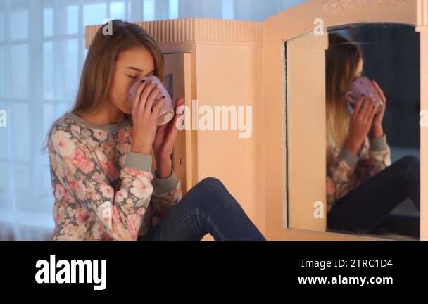 young beautiful teenage girl sitting on commode in the living room ...