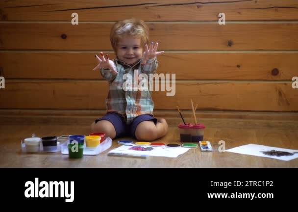 Creativity and education concept. Drawing. Happy cute boy colors his ...