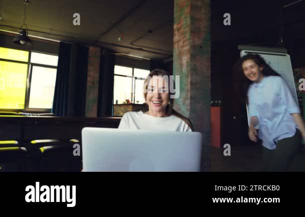 Attractive young office worker is happy about good work results, she is ...