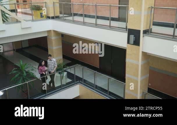 Two people after a seminar in a large study hall large format sheets ...