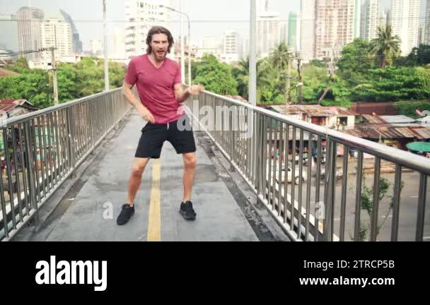 Man dancing on the urban street. Fit white man dancing in the middle of ...
