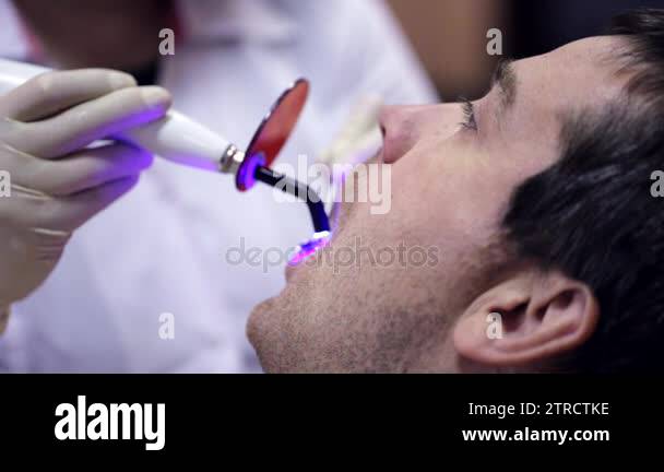 Dentist working with dental polymerization lamp in oral cavity Stock ...