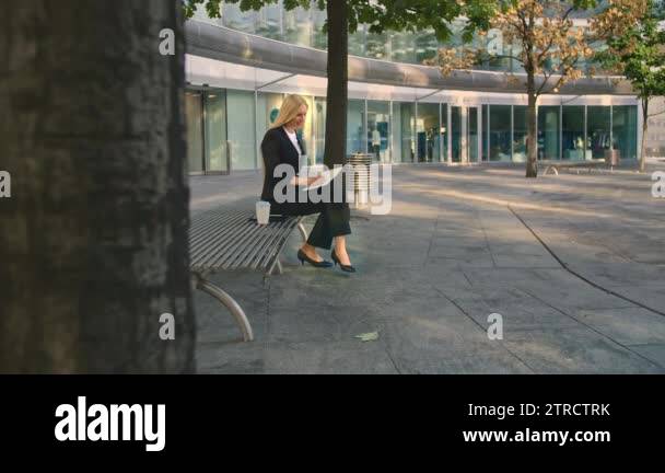 Successful business woman taking notes outdoors. Side view of elegant ...