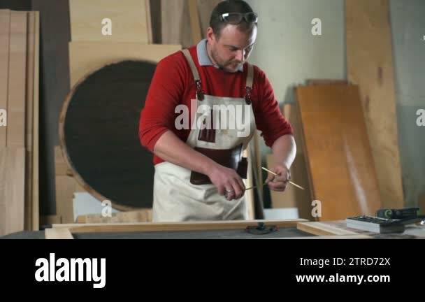 Carpenter measures needed length and makes a mark with a pencil in the ...