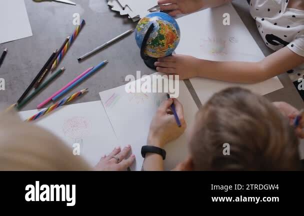 Top view. At the drawing lesson, the children sit at the table and draw ...