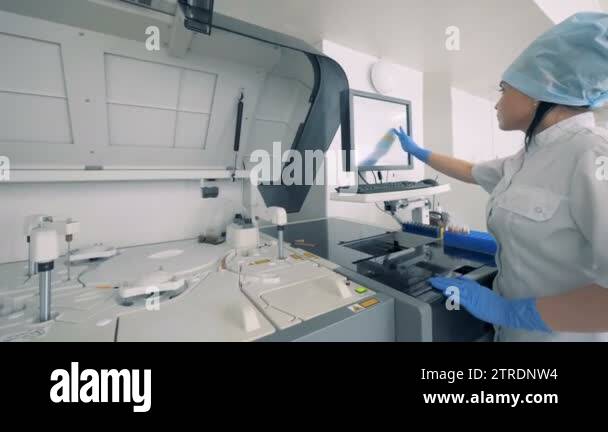 Biochemical analyzing machine is being managed by a lab worker at a ...