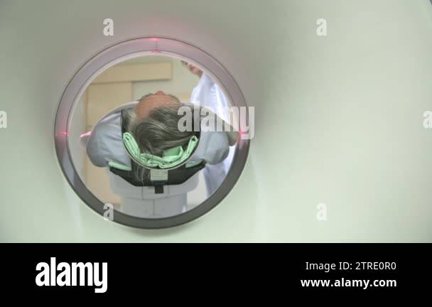 Patient in MRI machine for a CT scan. Senior man cover in blanket going ...