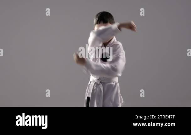 A very young karateka demostrates a self defence kata with several ...