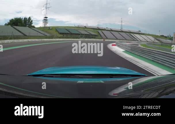 CLOSE UP LOW ANGLE VIEW: New blue personal sports car driving the lap ...