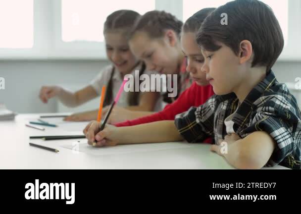 Four children draw together. Three girls and one boy try to paint ...