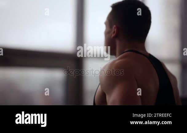 Back and side view of a strong male bodybuilder running on a treadmill ...