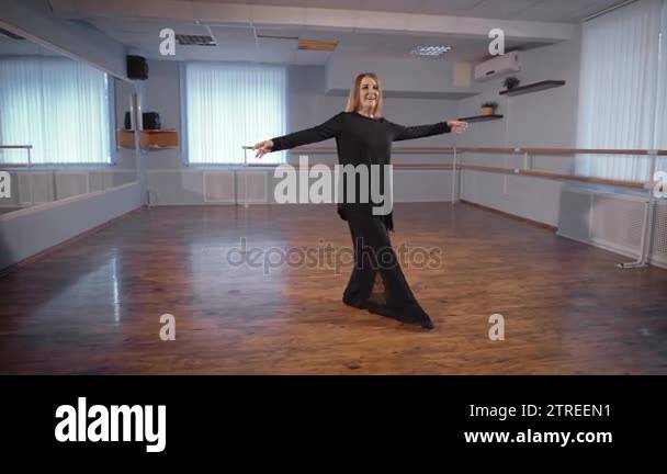 Beautiful white-haired woman in silk black suit dancing in classroom ...