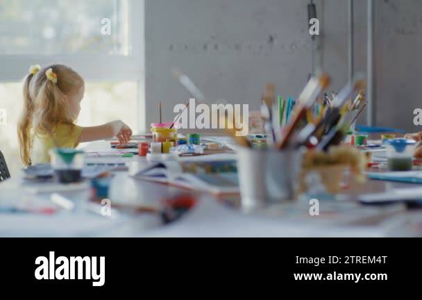 A little girl is drawing a kindergarten. Drawing lessons for preschool ...