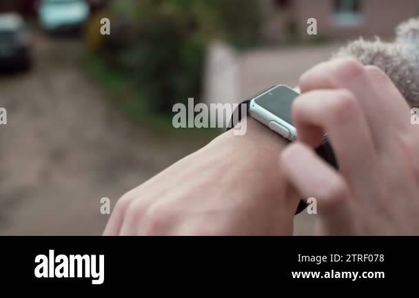 Woman using her smartwatch touchscreen device on a countryside ...