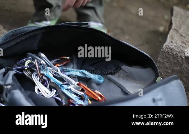 Rock climbing detail of climber hands grabbing some quickdraw and ...