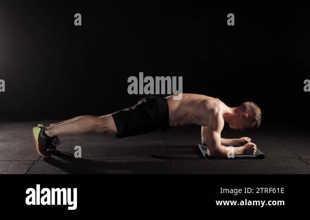 strong man is performing physical static exercise a plank, leaning by ...