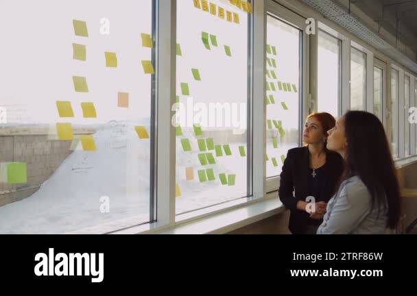 Two young beautiful women use window as board for Stickers Stock Video ...