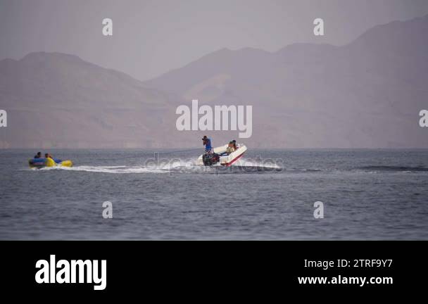 Water Extreme Bumper Tube Ride behind the Boat on Red Sea. Slow Motion ...