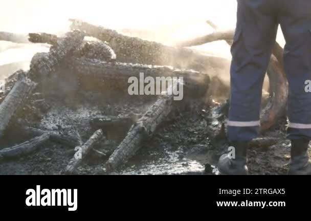 Fireman extinguishes a fire from a fire hose. Burned to the coals ...