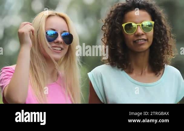 Two young women making dance moves while swinging their hips from side ...