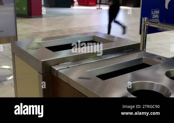 Woman throwing trash to the garbage can inside shopping mall Stock ...