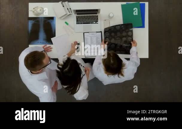 Medical team discussing diagnosis of xray images using special tablet ...