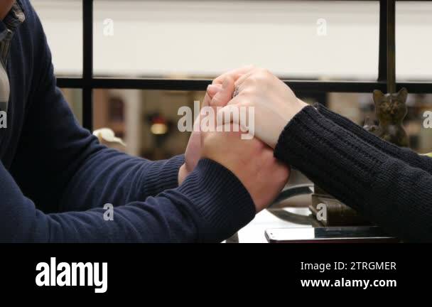 Young man in glasses are stroking and kissing the female hand tenderly ...