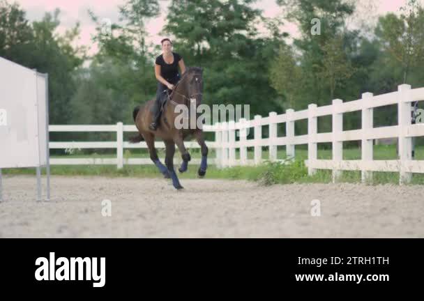 SLOW MOTION, DOF: Smiling female rider horseback riding beautiful dark ...