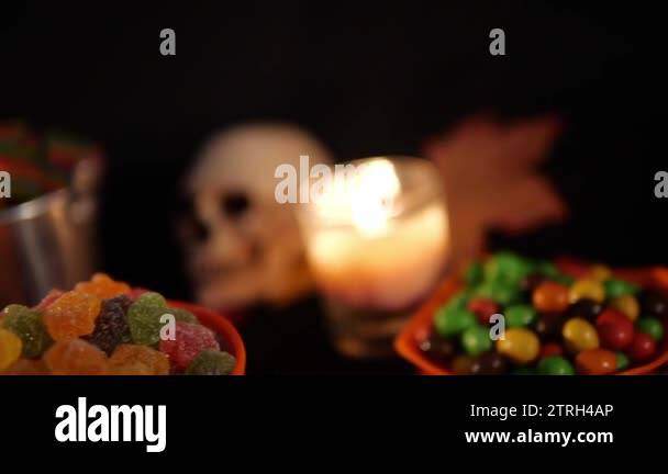 Halloween theme candy with burning candles over black background ...