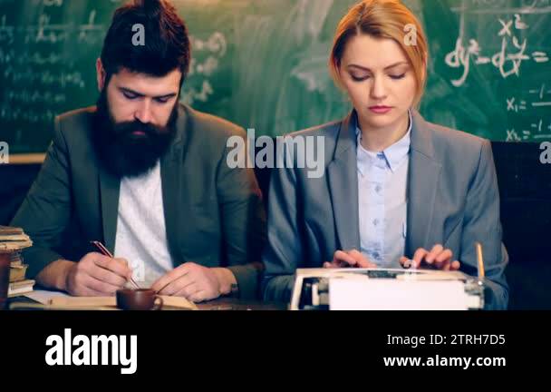 Two teachers are engaged in paper work in the school class. Learning ...