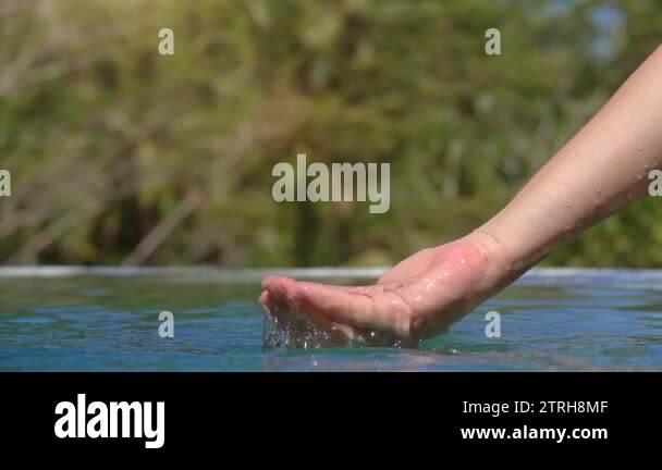 SLOW MOTION CLOSE UP: Caucasian female hand playing with water ...
