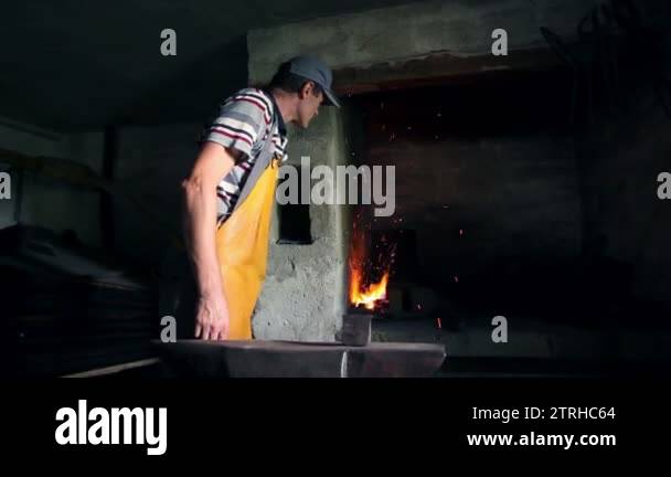 Blacksmith is blowing up air in the furnace to get sparkles Stock Video ...