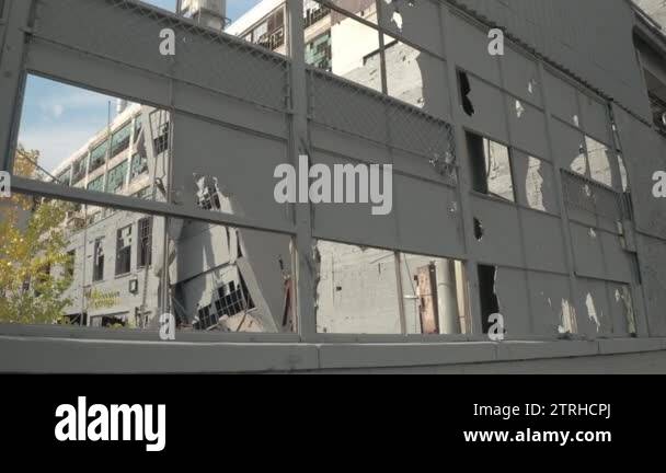 CLOSE UP Looking through the holes in crumbling walls of abandoned industrial building ...