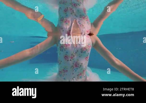 Japanese ballerina is dancing under water in pool on background of air ...