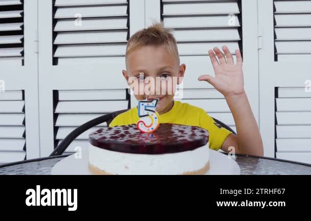 Cute happy boy celebrating its fifth birthday, in front of him ...