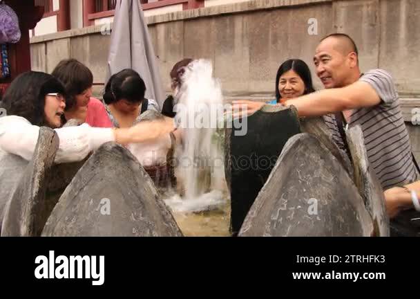 Asian tourists wash hands in the Huaqing hot springs water in Xian ...