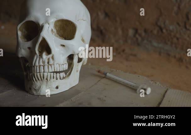 falling syringe near the skull. syringe falling down spraying blood ...