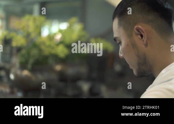 Asian barber doing haircut in male salon. Hairstylist working with ...