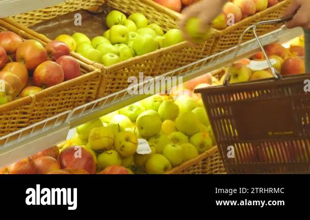 Male hands selecting fresh apples in grocery store produce department ...