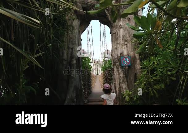 People walk by the suspension bridge at the Palawan beach at Sentosa ...