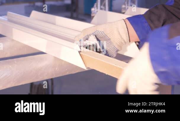 Hands of worker using a silicone tube for repairing of window indoor ...