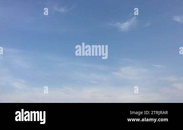 White sunset clouds disappear in the hot sun on blue sky. Loop features time lapse motion clouds ...